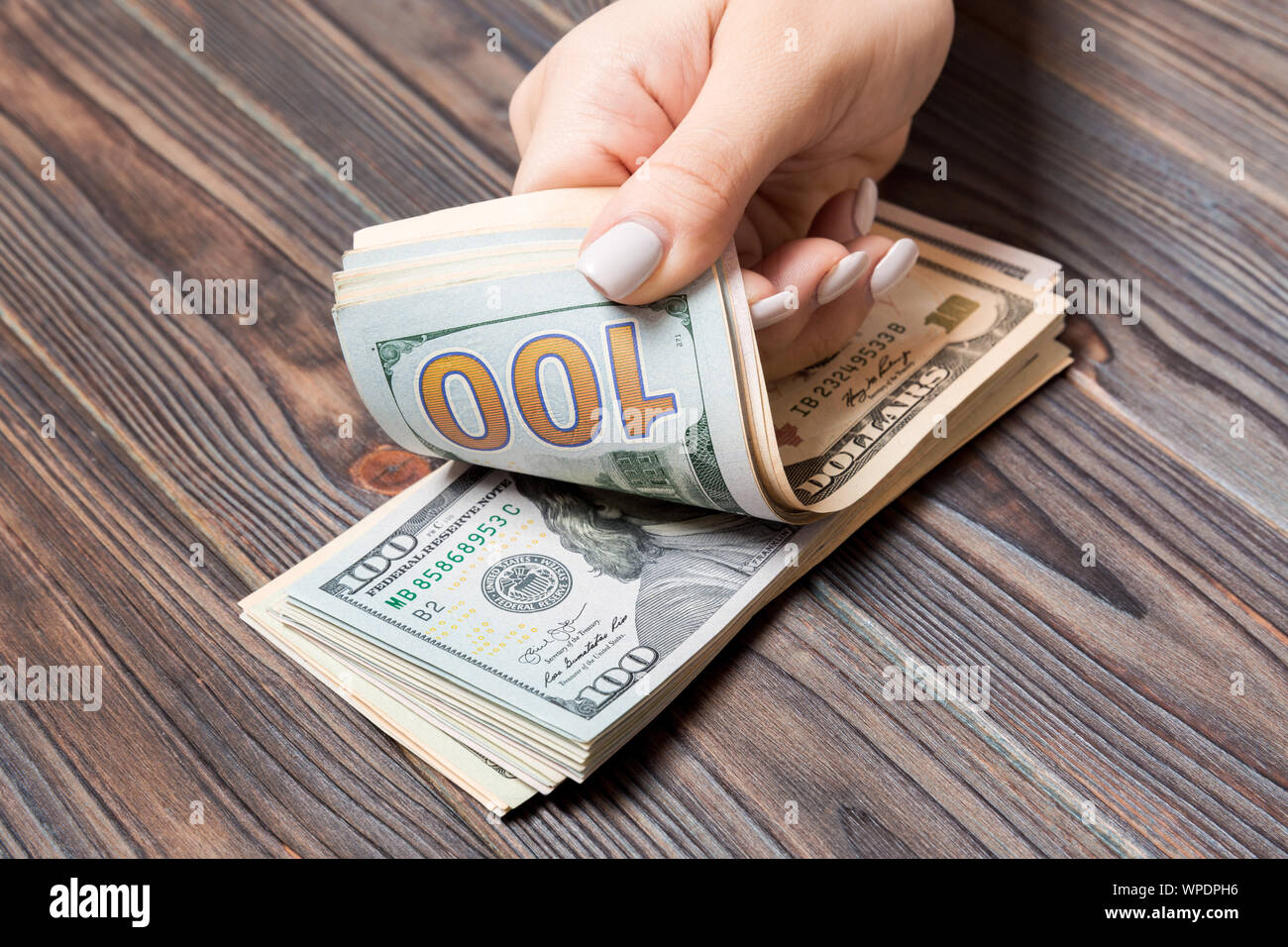 Perspective view of female hands counting money. One hundred dollar ...