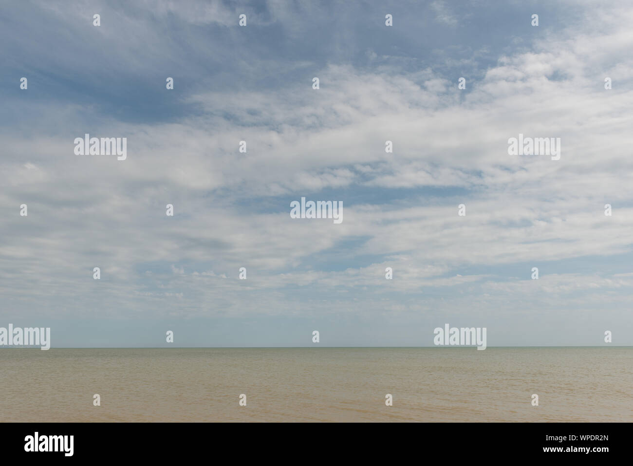 Bleak shingle shoreline with views across English Channel at high tide ...