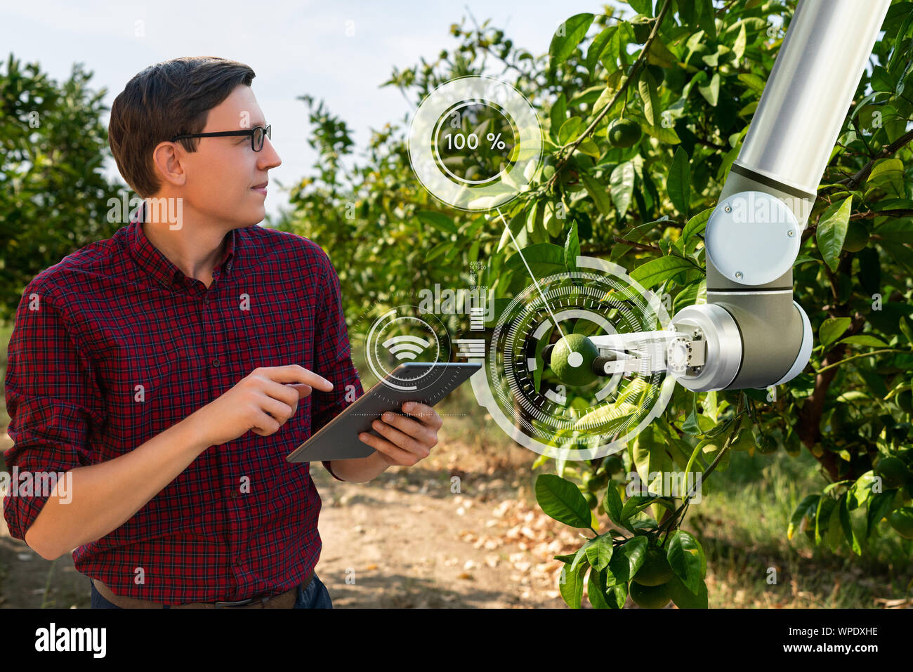 Farmer controls robotic arm with a tablet. Smart farming and digital ...