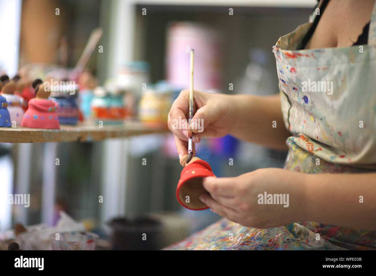 The hands of a woman artist at work in a craft workshop for the ...