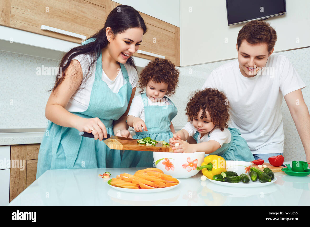 Happy family is cooking dinner in the kitchen Stock Photo - Alamy