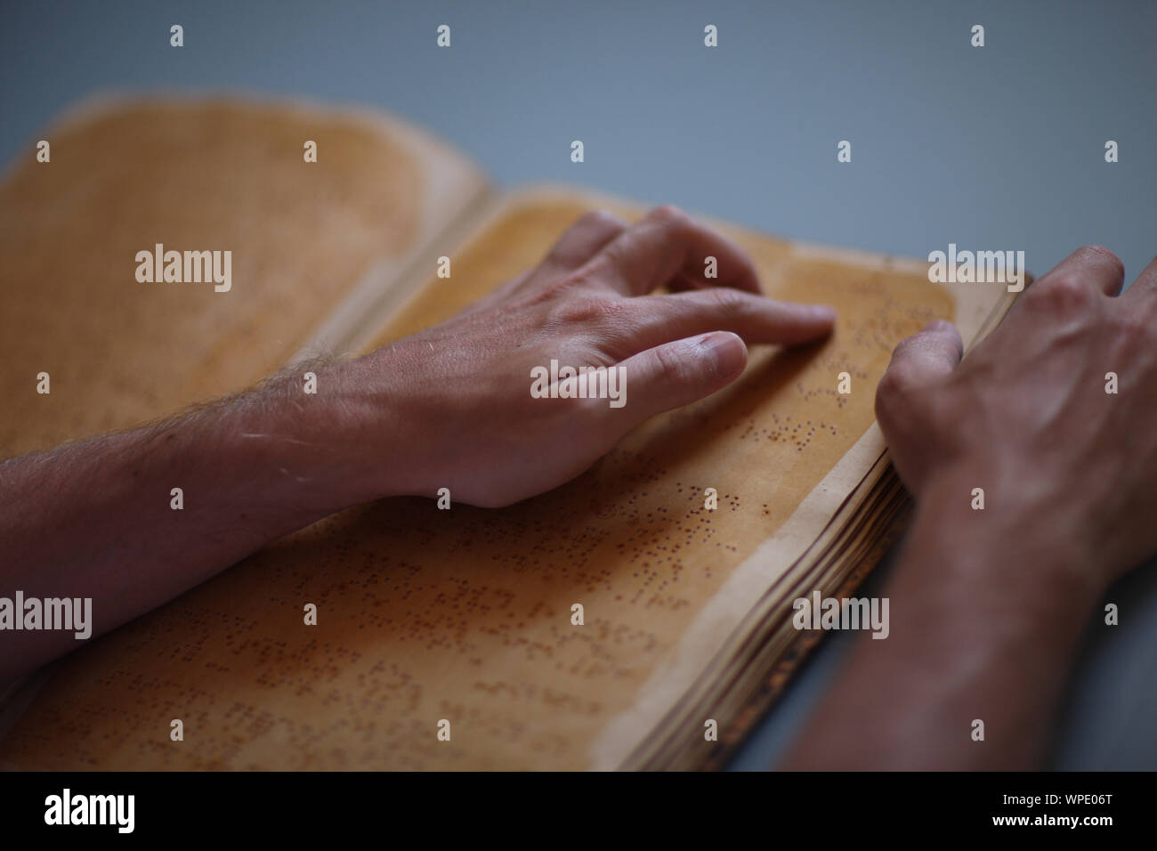 The hands of a blind man reading a book with a special Braille Stock ...