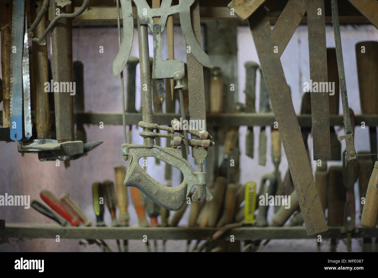 Carefully hanging hand tools in the metal workshop Stock Photo - Alamy