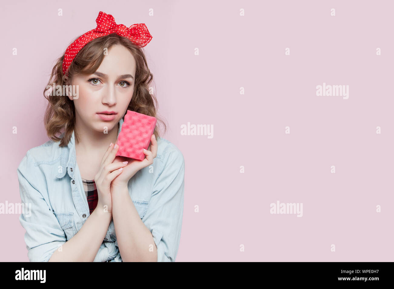 Beautiful young woman with pin-up make-up and hairstyle with cleaning ...