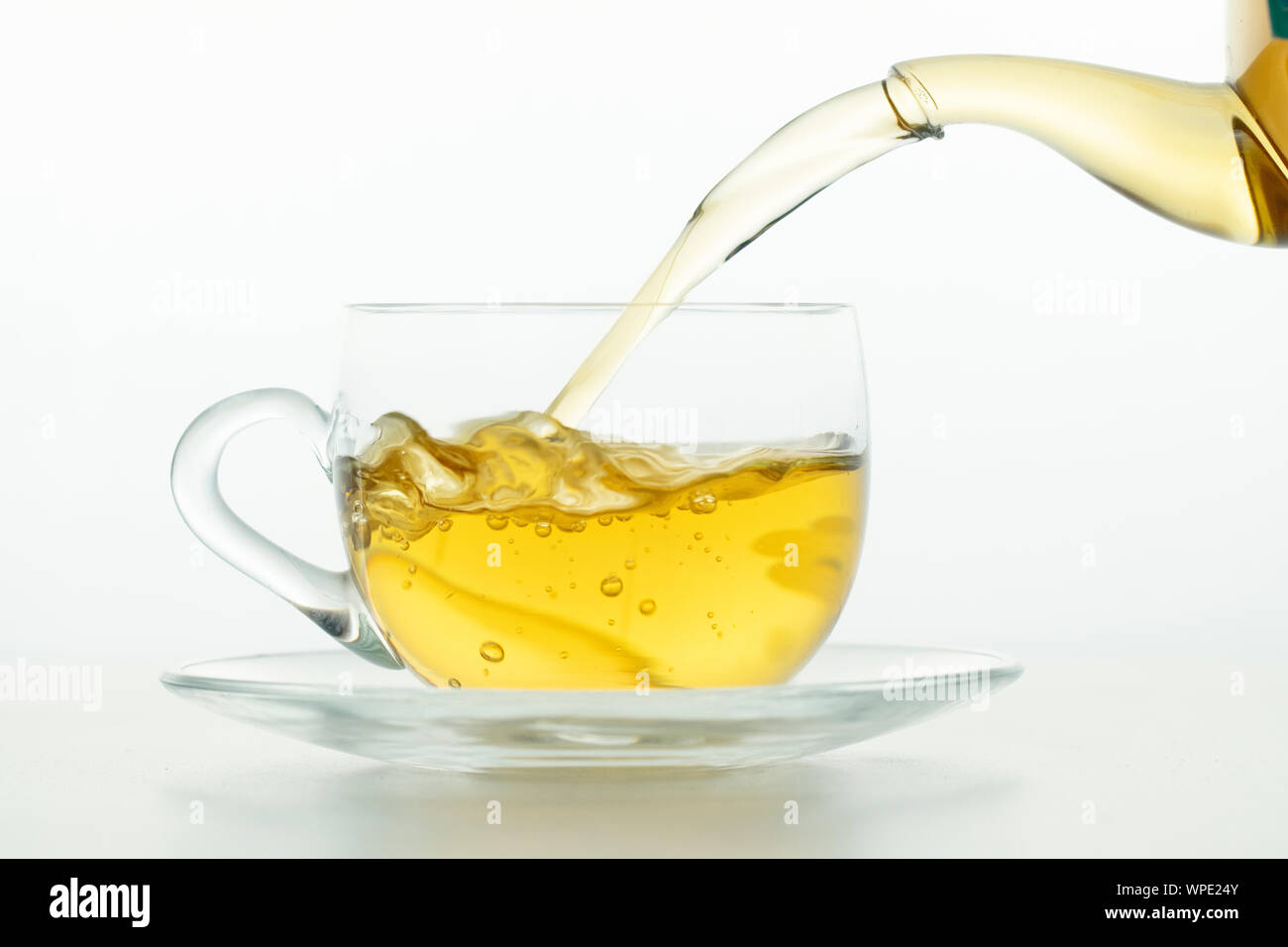 Tea pouring into tea cup on white background Stock Photo - Alamy