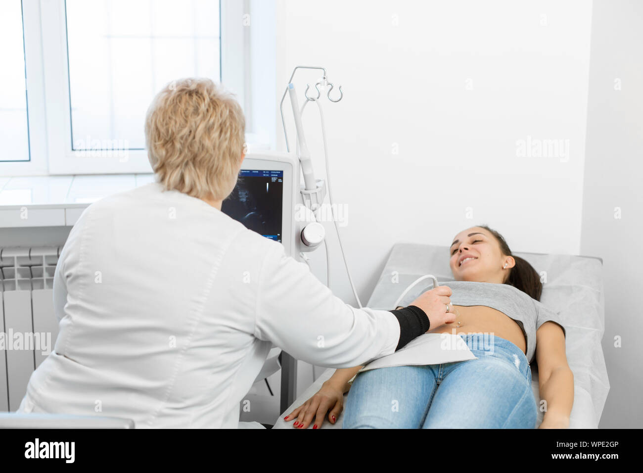 The doctor is preparing to conduct ultrasound research. smears the gel ...