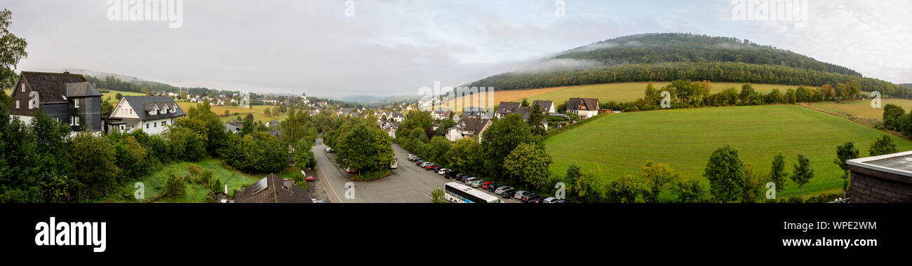 Wide panorama of a valley in Sauerland, Germany, with the spa village ...