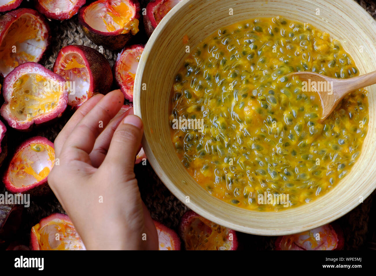Top view woman hand processing passion fruit by cut in half Passiflora ...