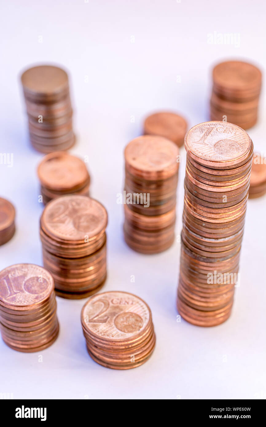 Towers made of coins on a white background Stock Photo - Alamy