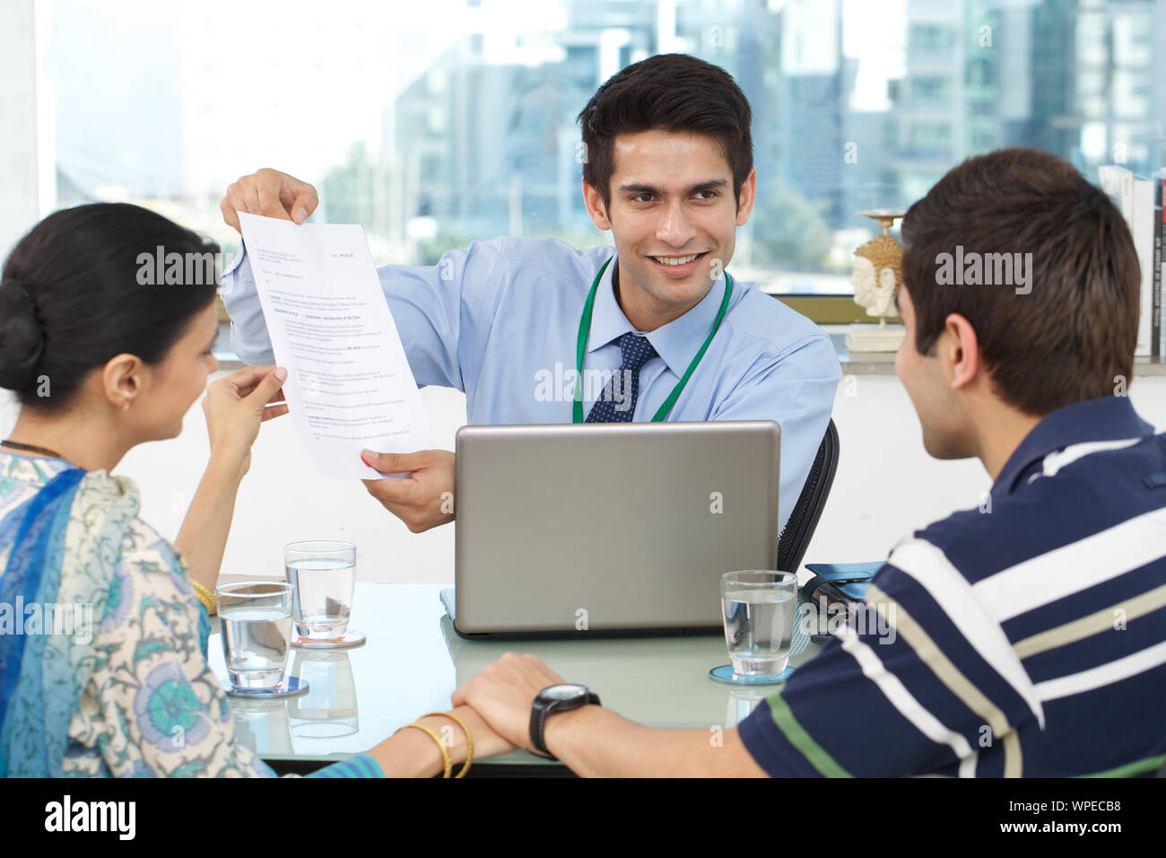 Executive explaining document to a couple Stock Photo - Alamy