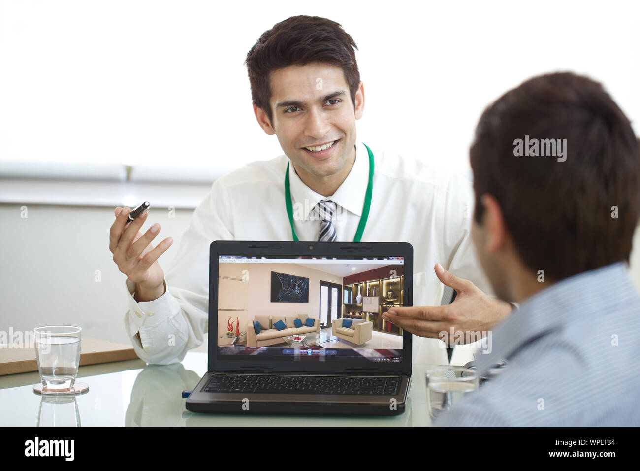 Real estate agent showing house plan on laptop Stock Photo - Alamy