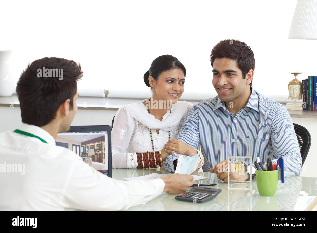 Bank manager giving loan cheque to young couple Stock Photo - Alamy