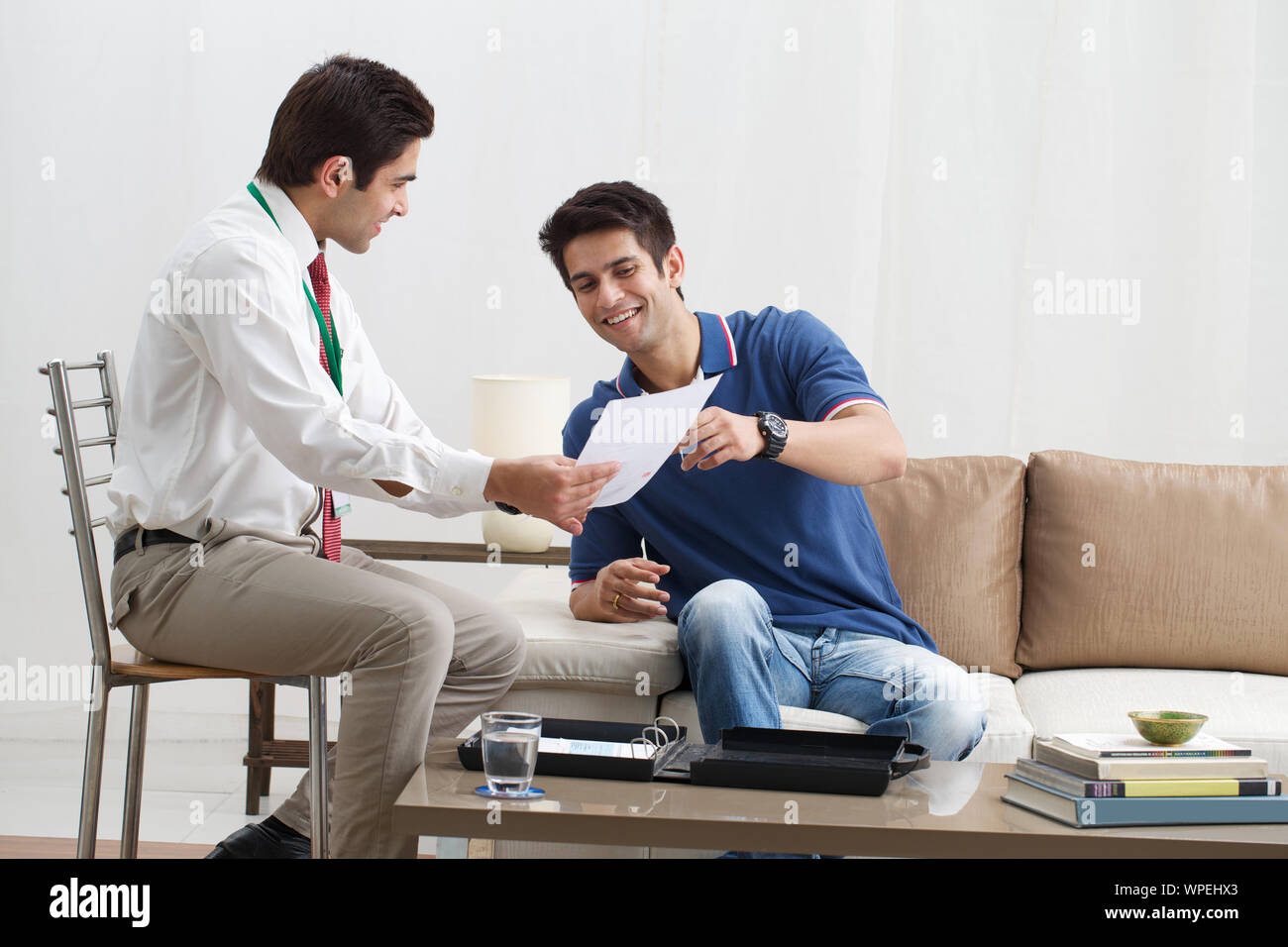 Financial advisor explaining on document to a client Stock Photo - Alamy