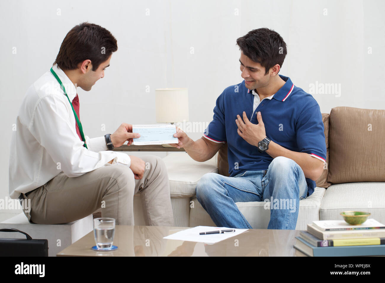 Financial advisor giving cheque to a young man Stock Photo - Alamy