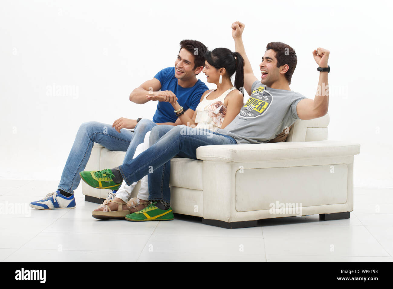 Group of friend watching TV and smiling Stock Photo - Alamy