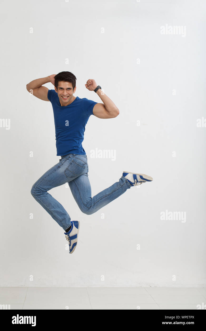 Young man jumping in mid air Stock Photo - Alamy