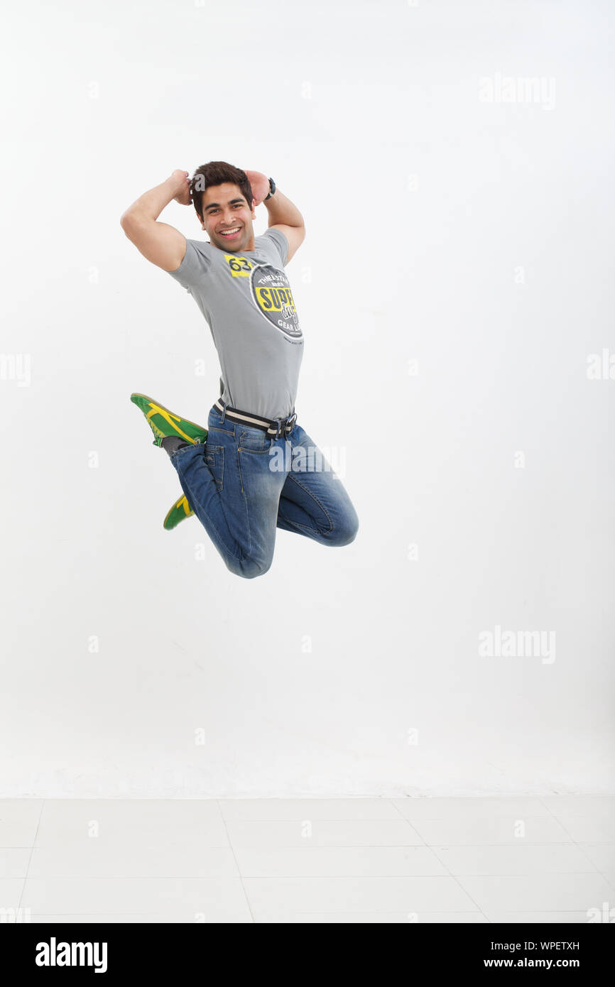 Young man jumping in mid air Stock Photo - Alamy