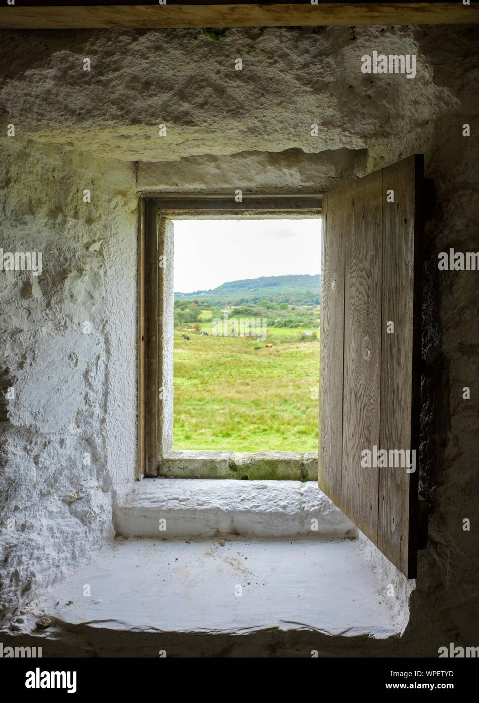 View through an open shuttered window to farmland in countryside ...