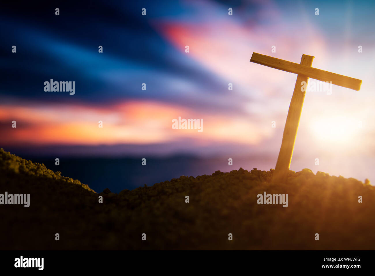 Conceptual wood cross or religion symbol shape over a sunset sky with ...