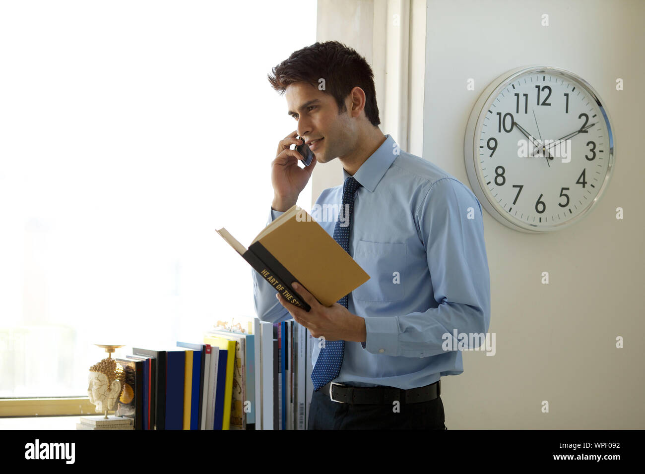 Talking on phone businessman clock hi-res stock photography and images ...