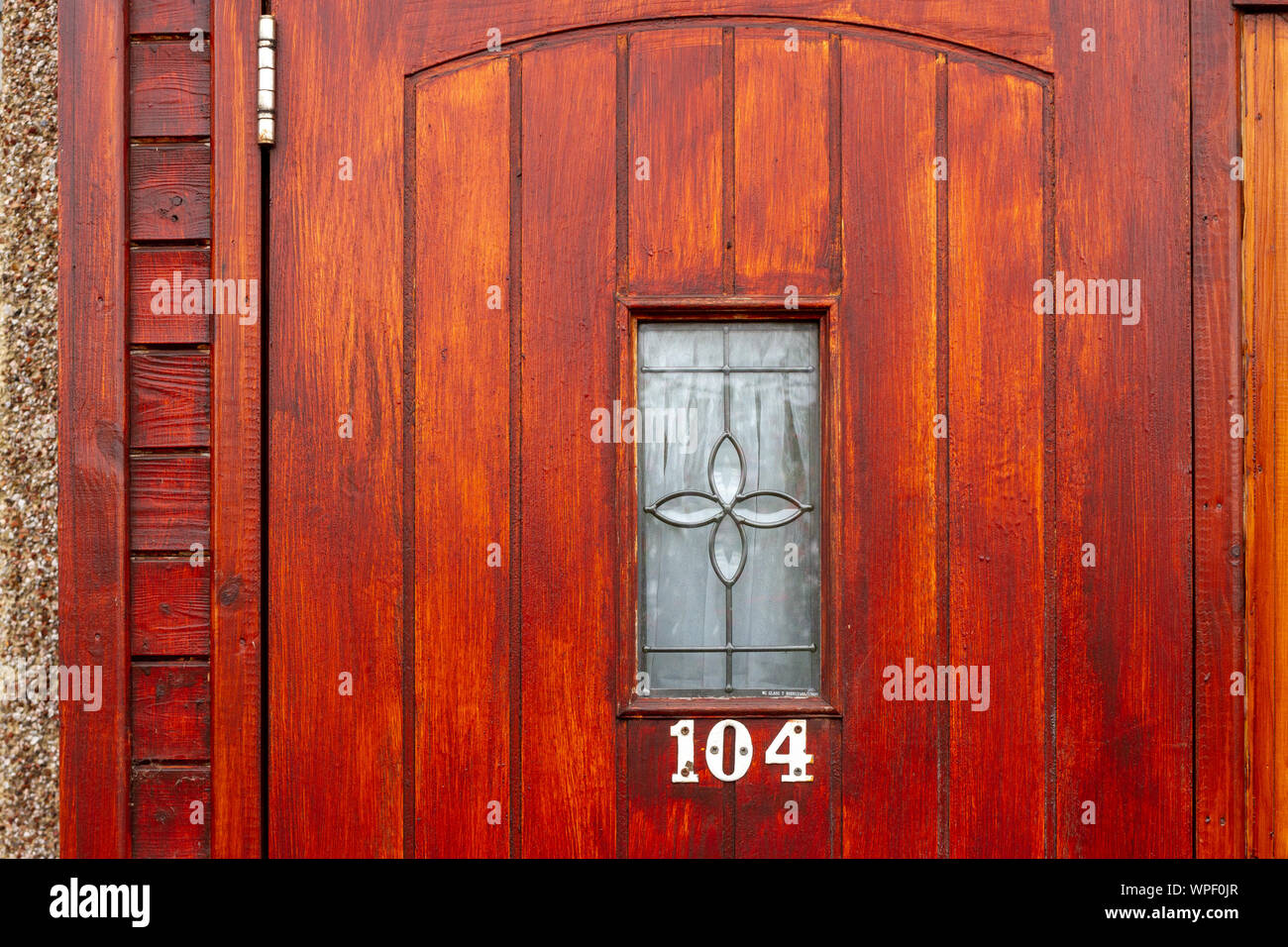 House number 104 on a red wood door with glass window Stock Photo - Alamy