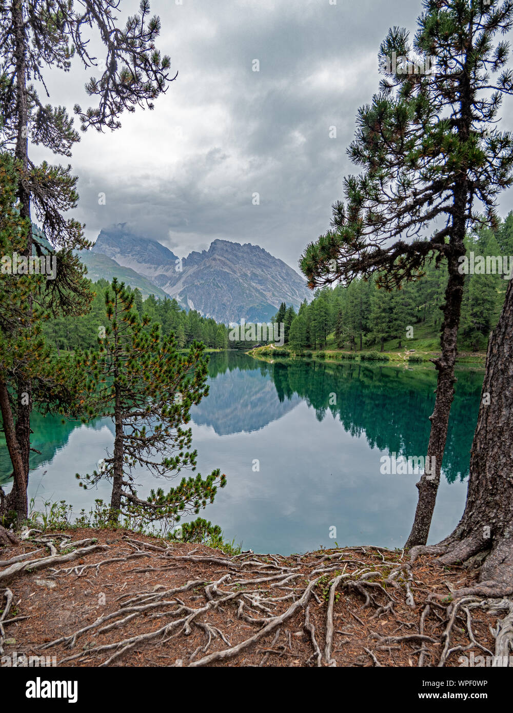 A high alpine mountain lake perfectly reflects the surrounding ...