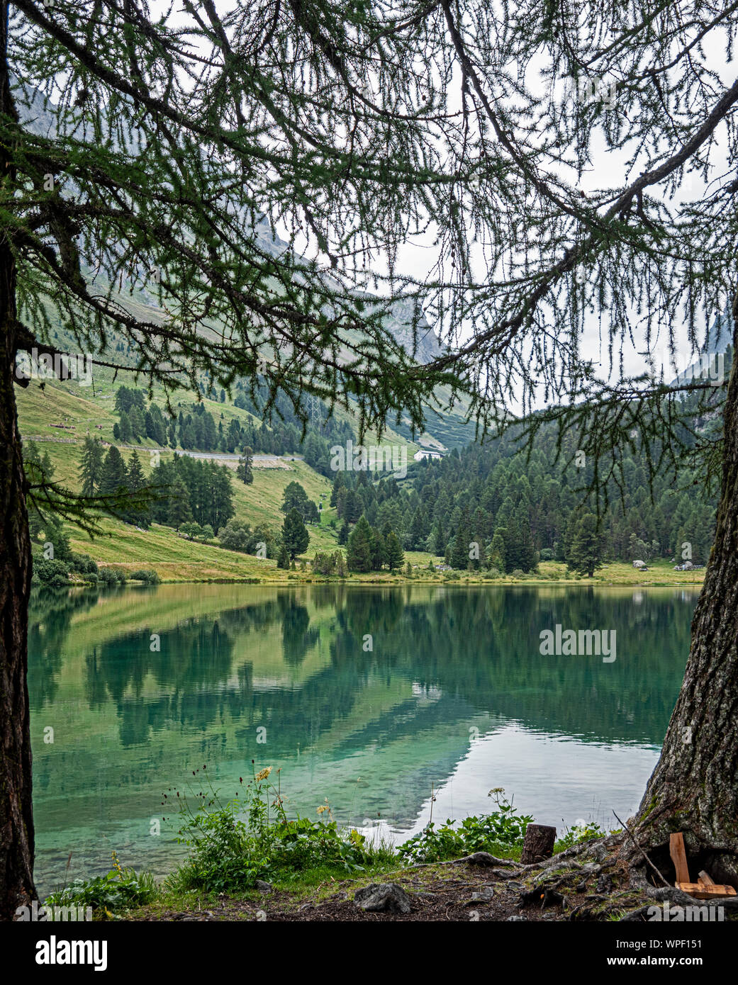 A high alpine mountain lake perfectly reflects the surrounding ...