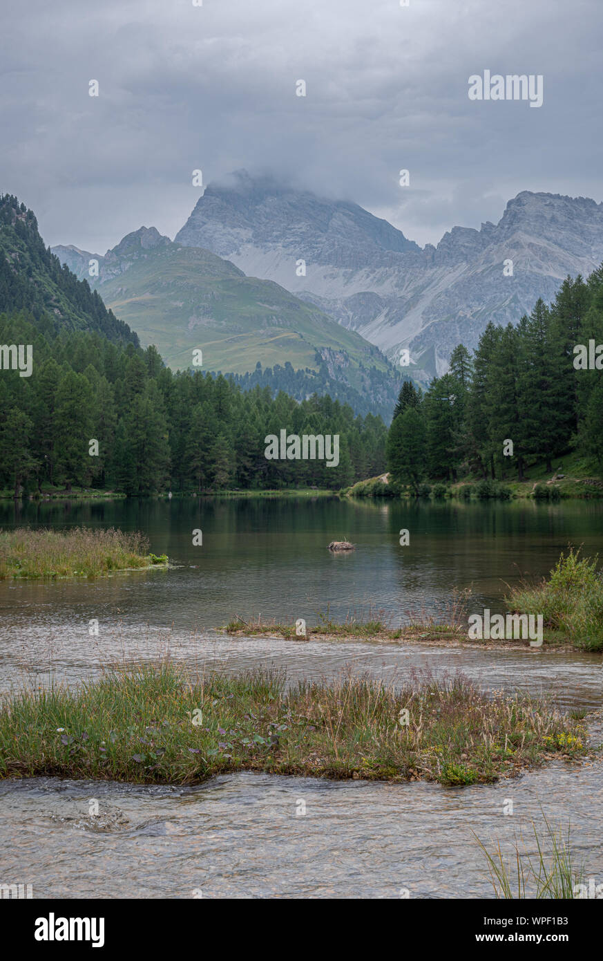 A high alpine mountain lake perfectly reflects the surrounding ...