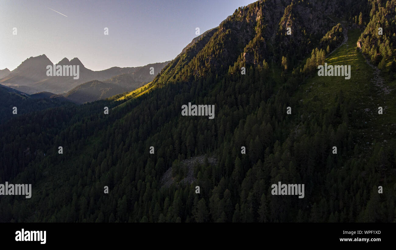 Aerial drone views of a lush green alpine valley and the surrounding ...