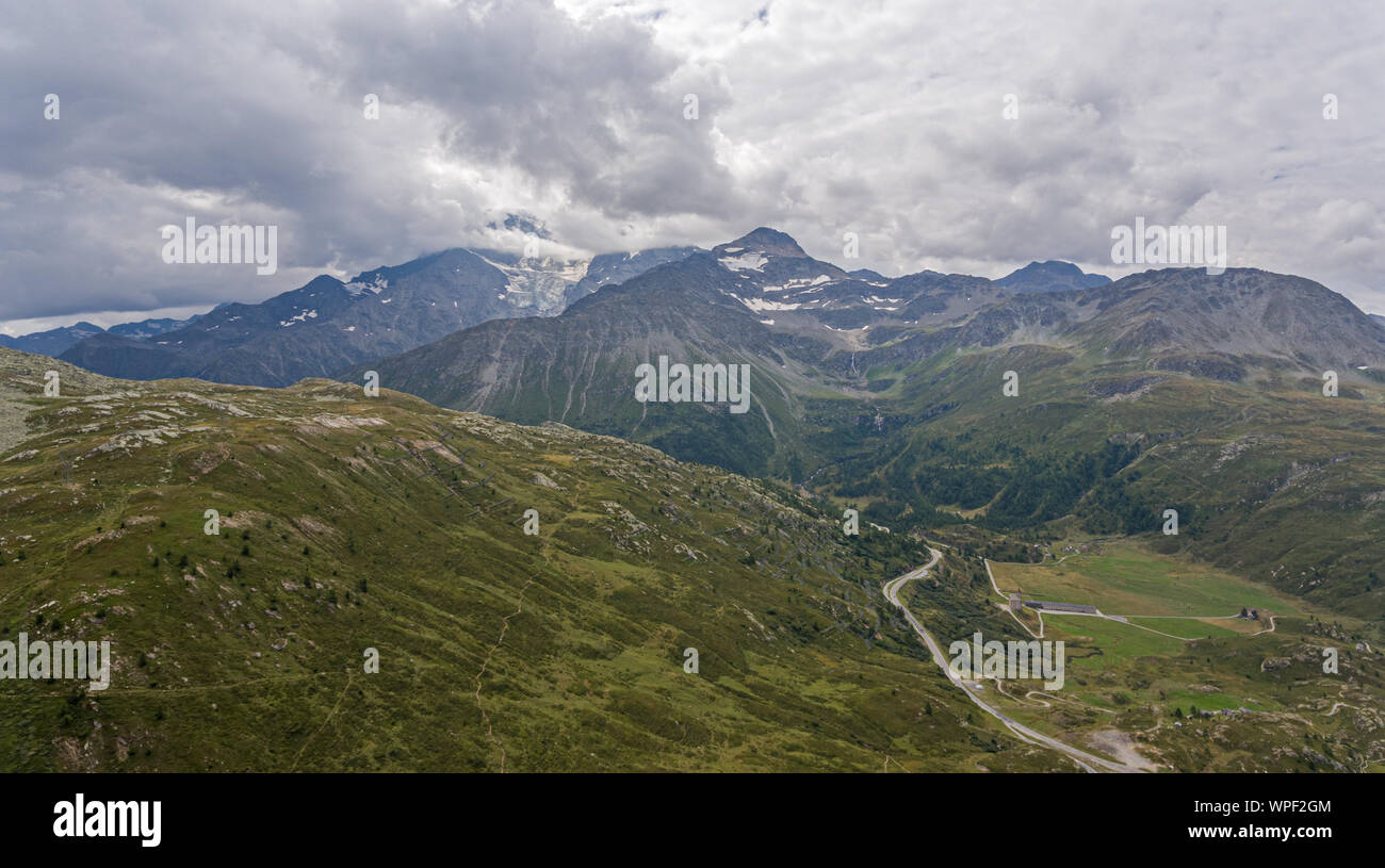 A high alpine mountain valley and mountain road pass. The road passes ...