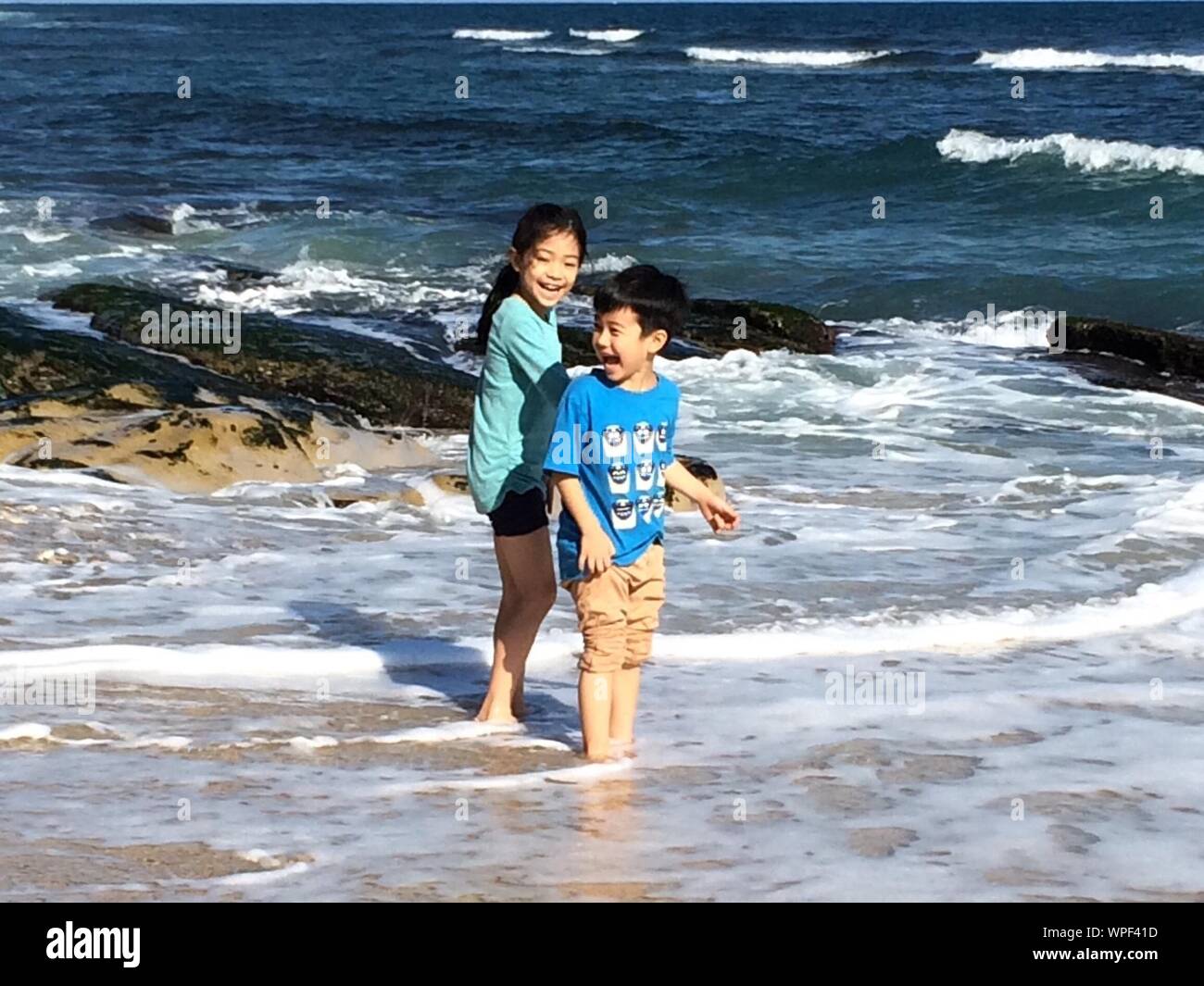 Two children playing in the sea hi-res stock photography and images - Alamy