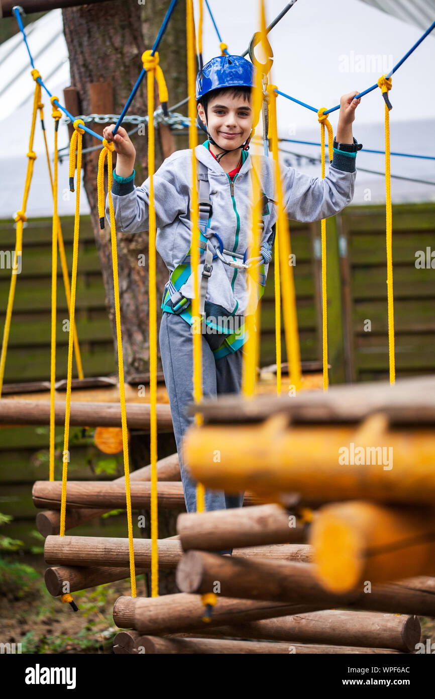 Young boy climbing pass obstacles in rope. Child in forest adventure ...