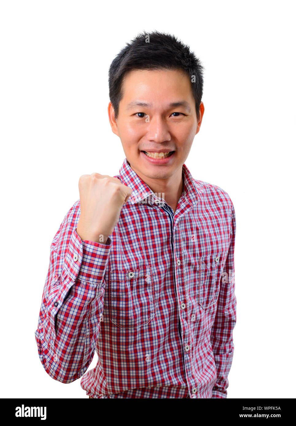 Happy excited young Asian man raising his fists doing yes gesture ...