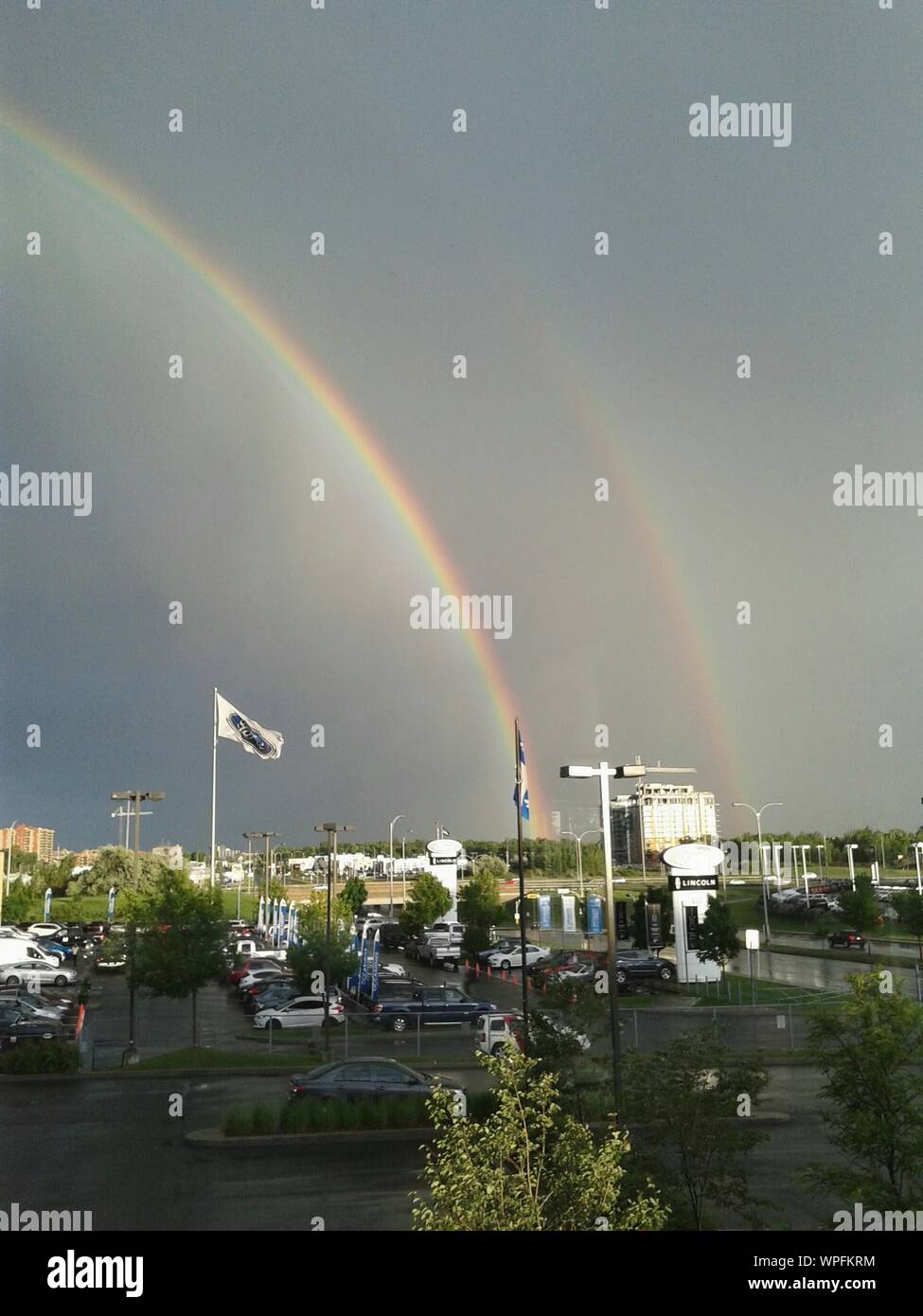 Rainbow Over City At Night Stock Photo - Alamy