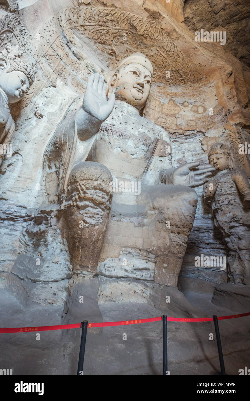 Weathered Buddha statue in cave 3 of the Yungang Grottoes near Datong ...