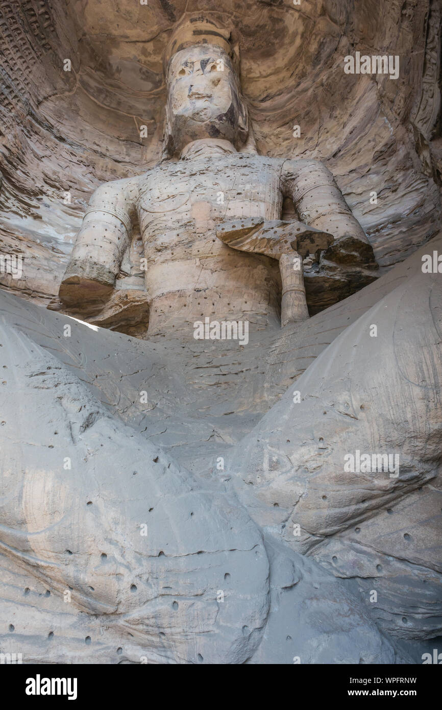 Large weatherworn Buddha statue in cave 17 of the Yungang Grottoes near ...