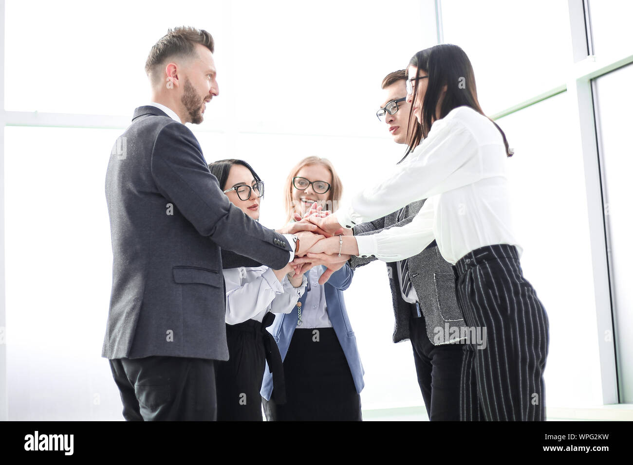 business team showing their unity while standing in the office Stock ...