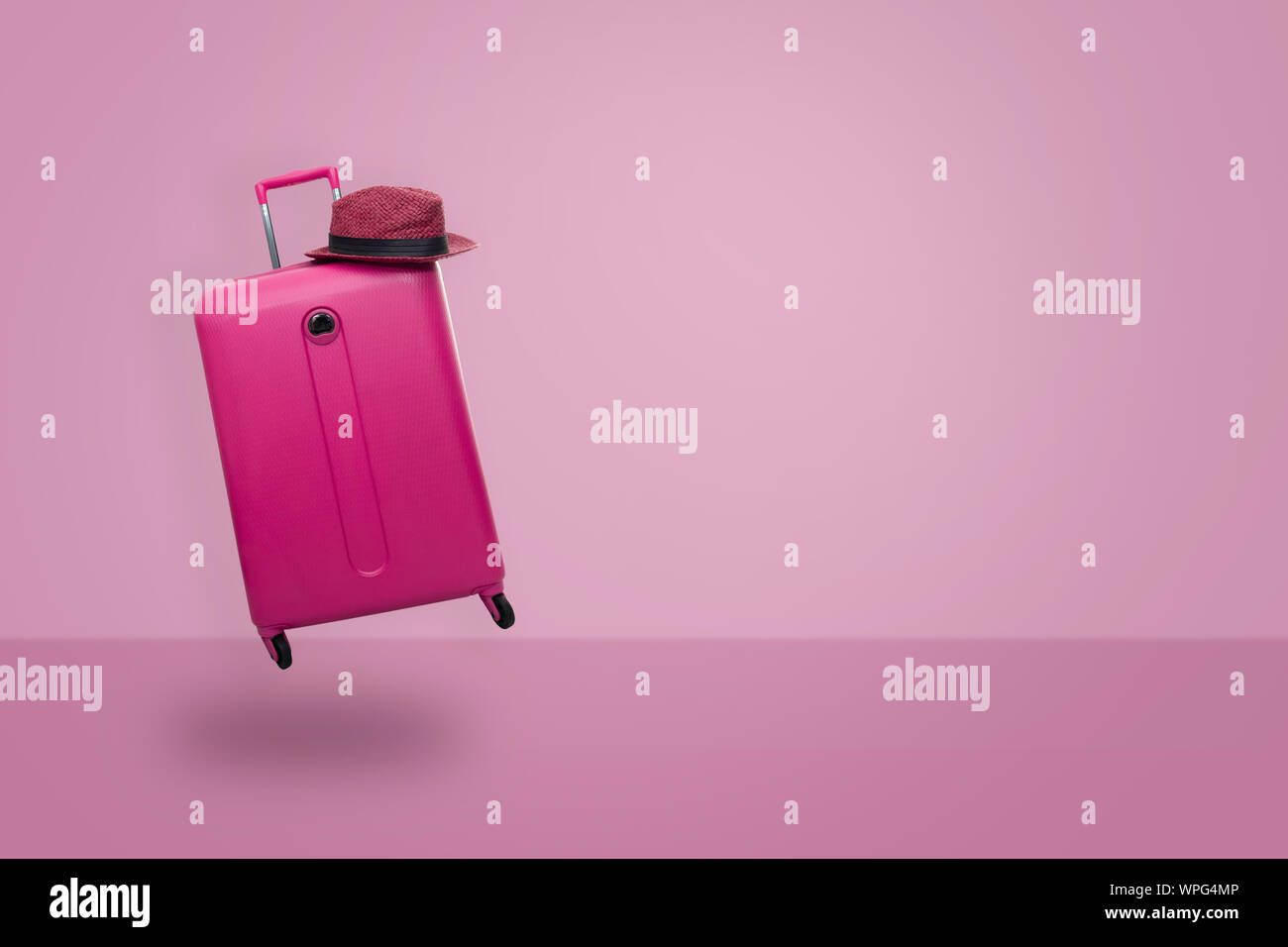 Pink suitcase with hat on pastel pink background. travel concept ...