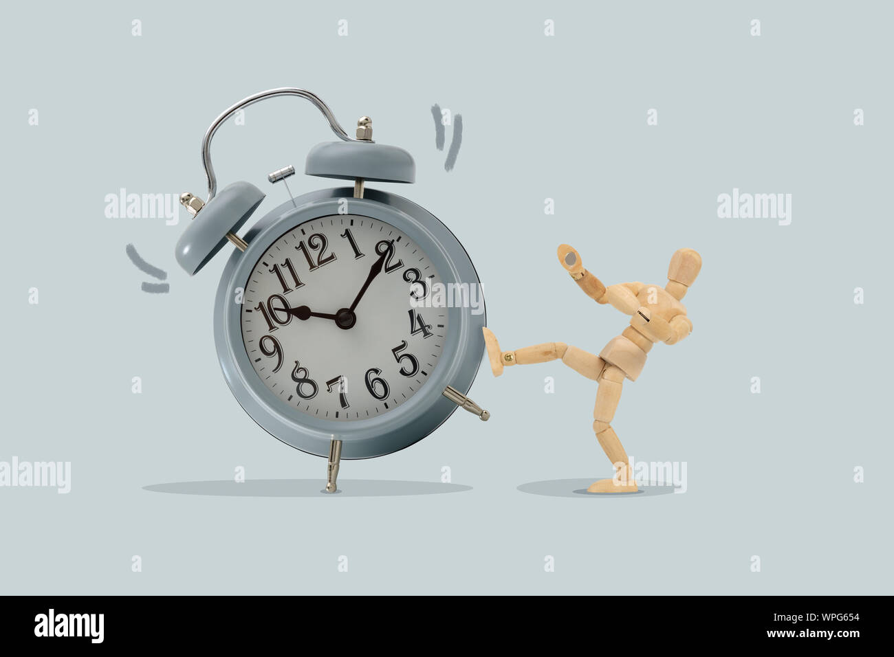 Wooden dummy kick a big clock, Isolated on blue background, Idea and ...