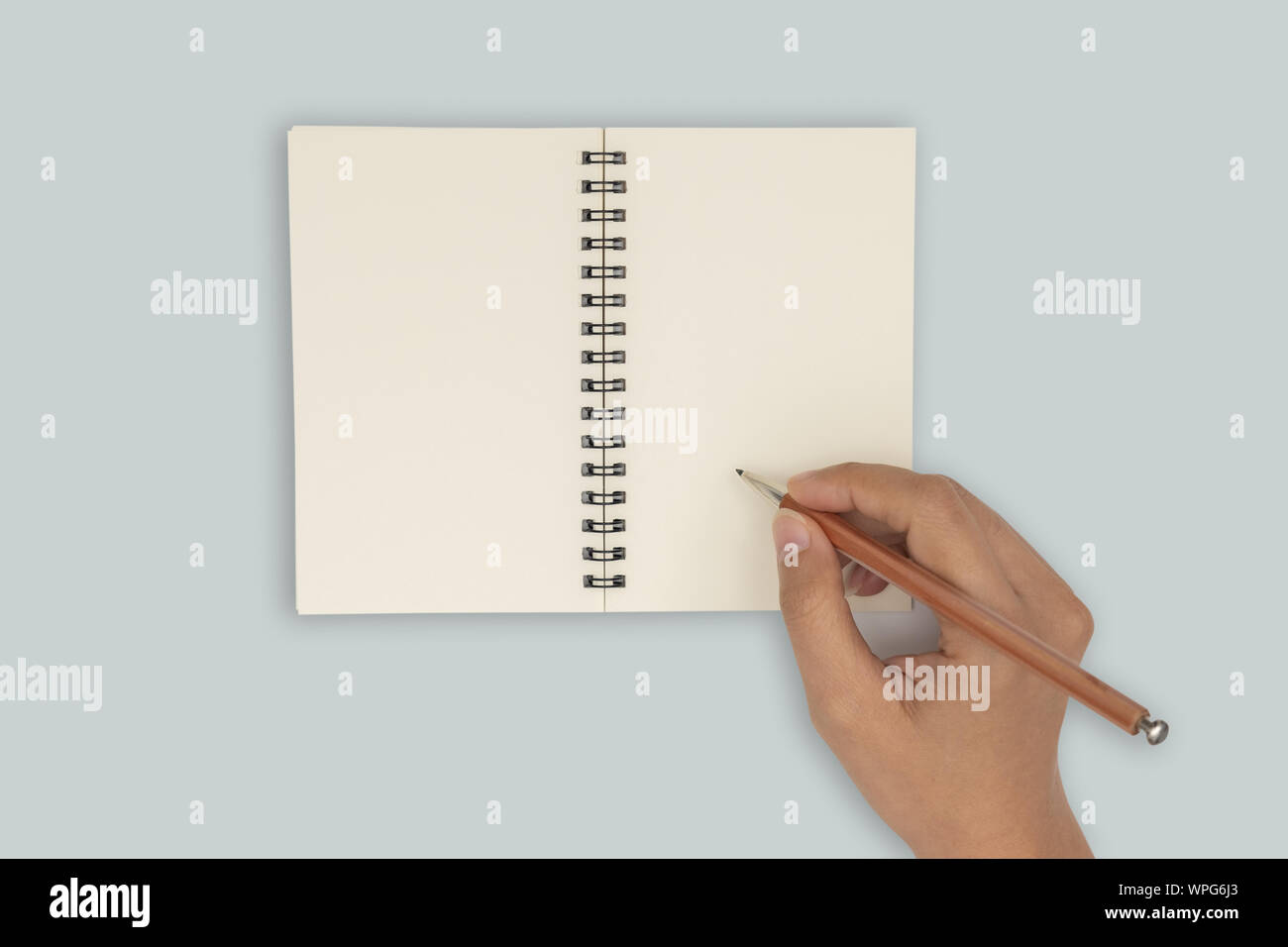 Top view- two hands hold a empty book spread and writing a notebook ...