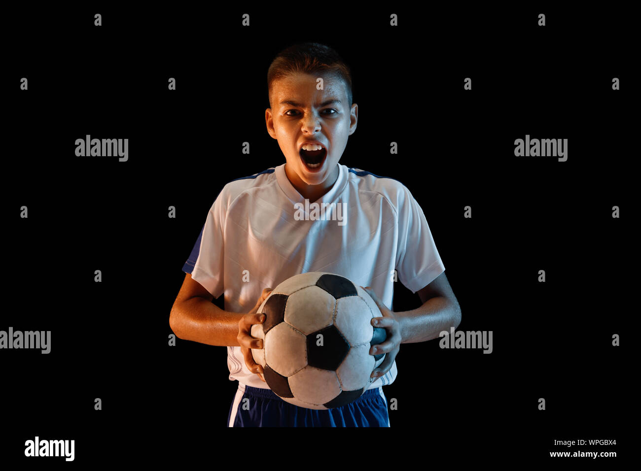 Young boy as a soccer or football player in sportwear making a feint or ...