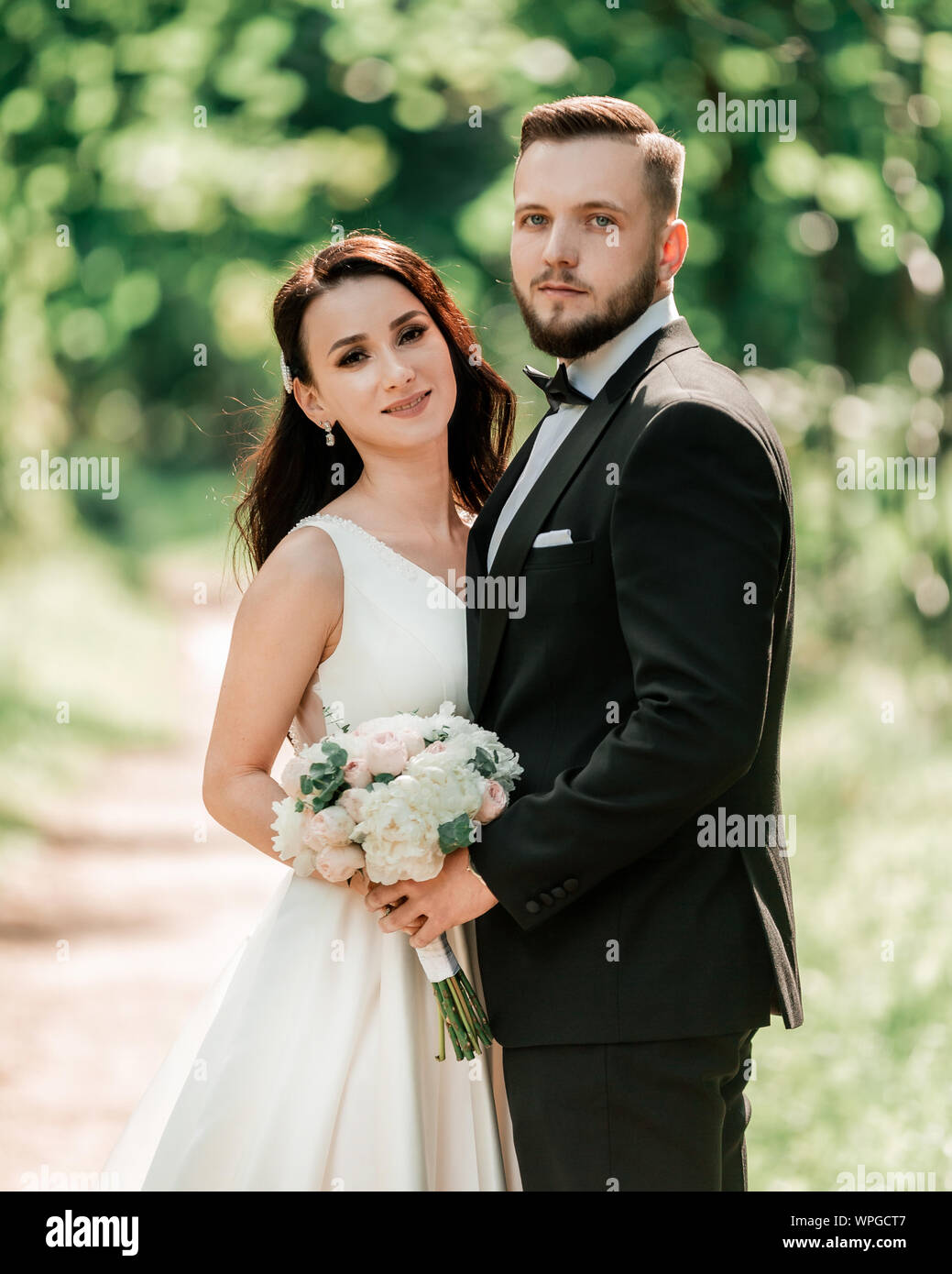 happy bride and groom standing under the wedding arch Stock Photo - Alamy