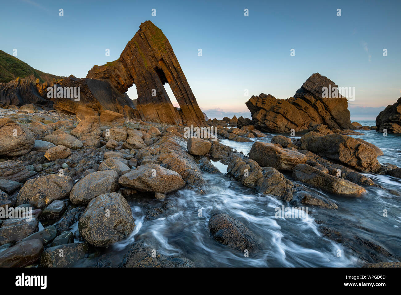Sunrise illuminates Blackchurch Rock at Mouthmill Beach on the North ...