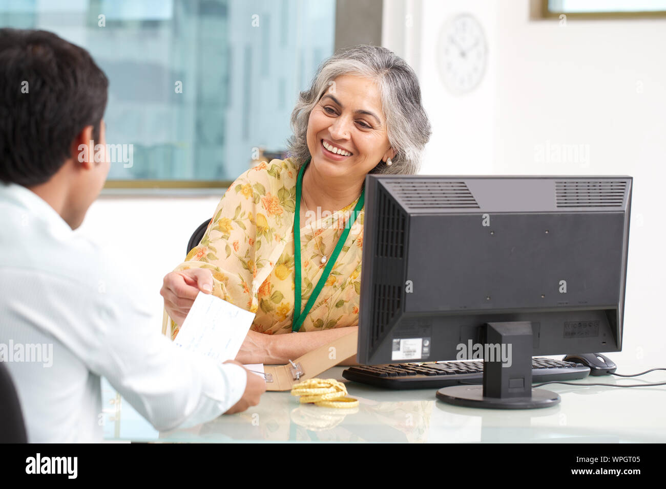 Bank manager giving cheque to her customer as gold loan Stock Photo - Alamy