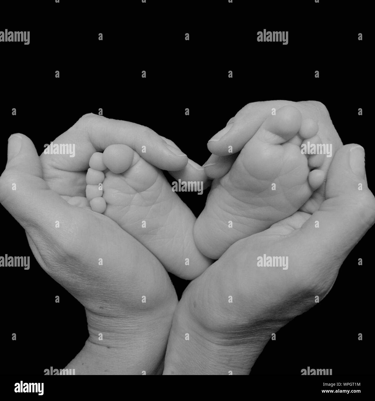 Mother hand holding babys feet hi-res stock photography and images - Alamy