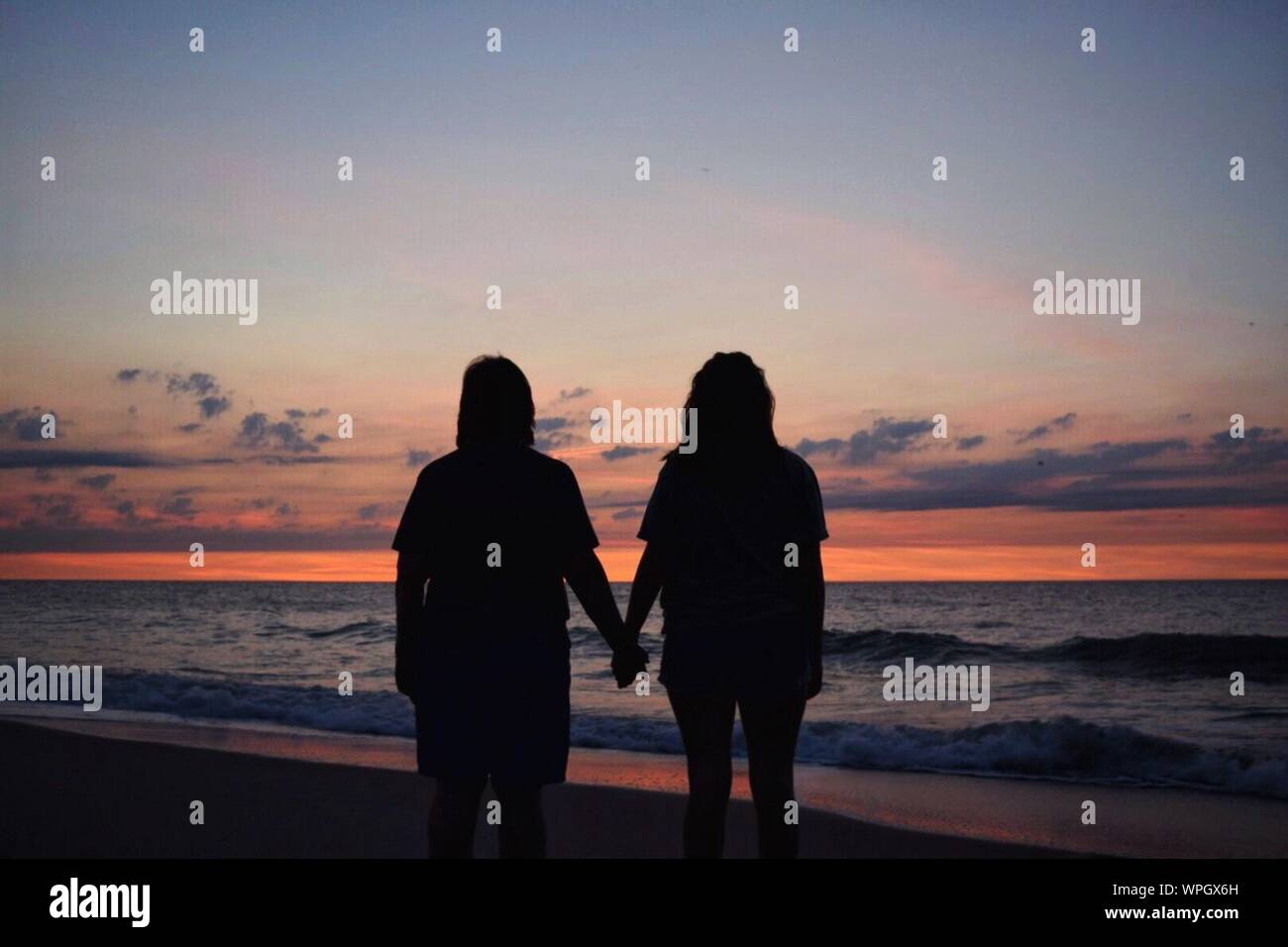 Beach sunset friends holding hands hi-res stock photography and images ...