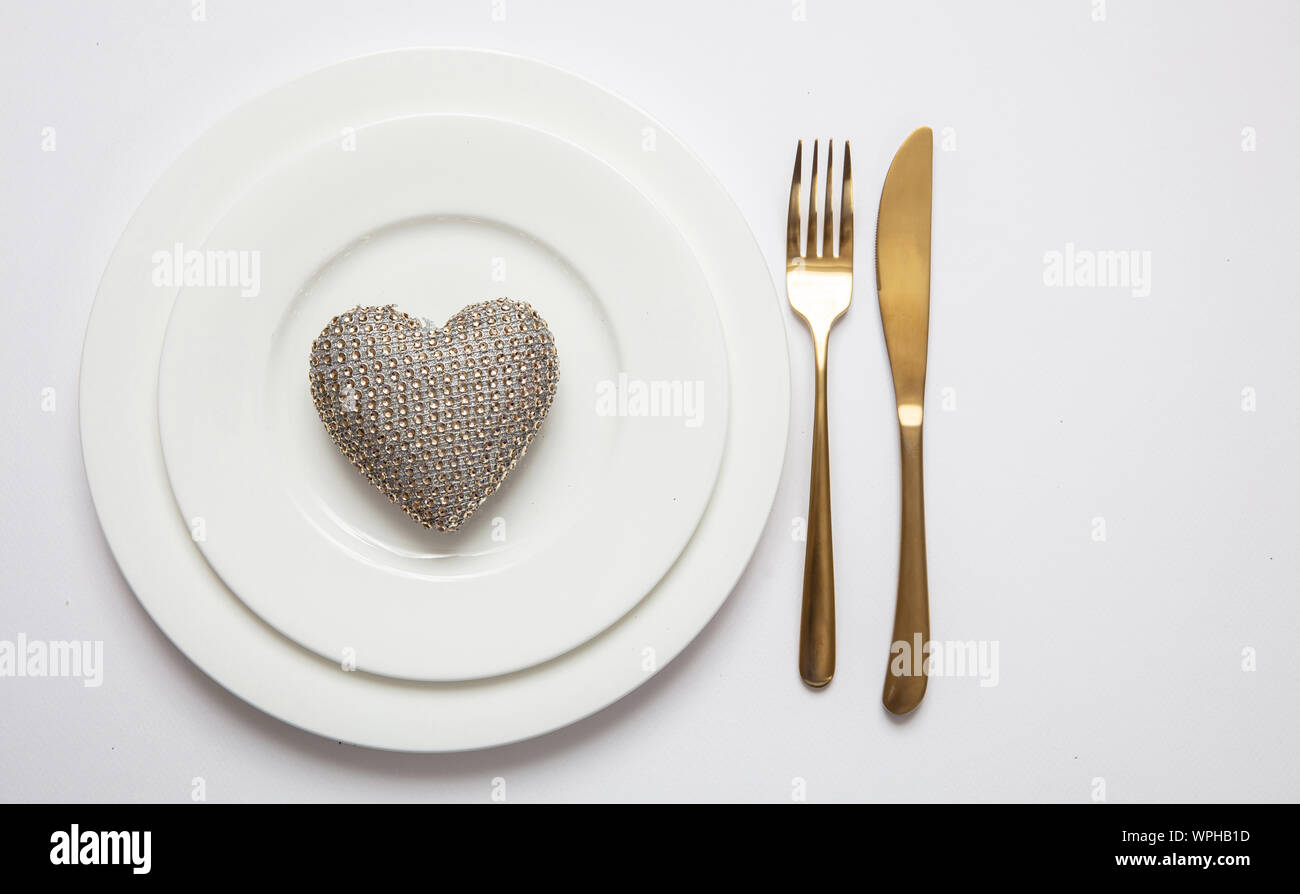 Wedding anniversary dinner table setting, Gold fork and knife on white ...