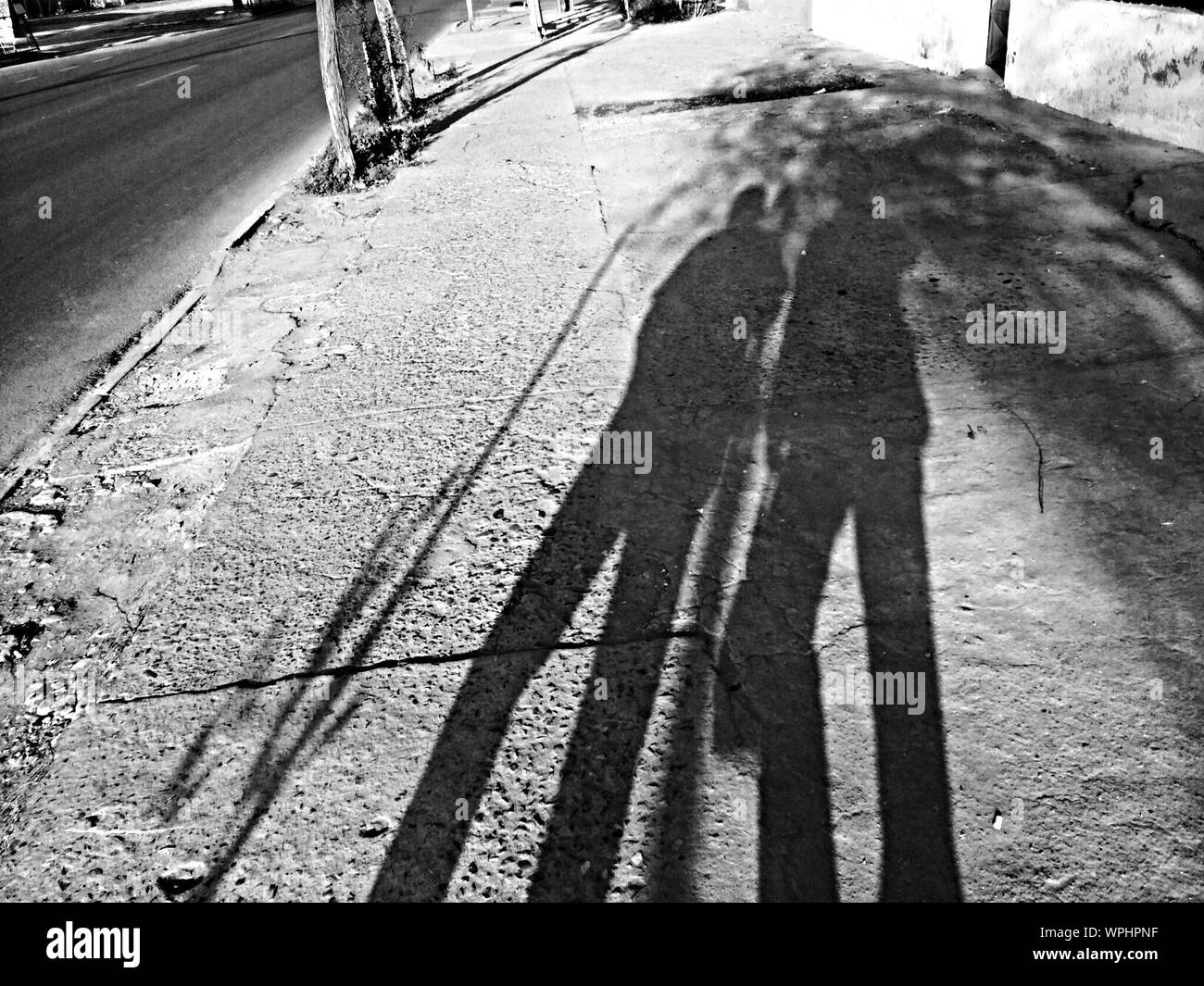 Shadow Of Two People Standing On Sidewalk Stock Photo - Alamy