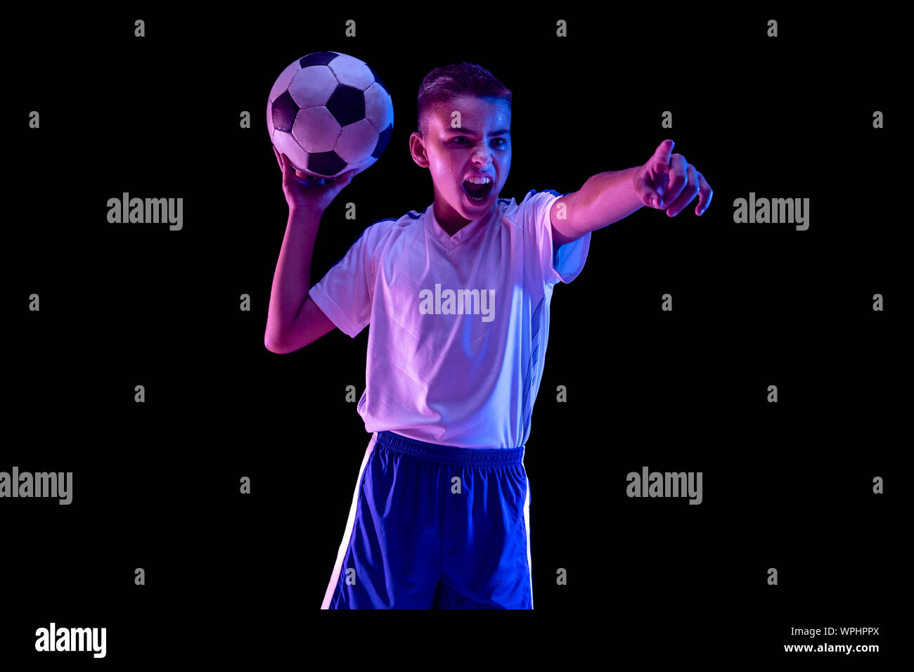 Young boy as a soccer or football player in sportwear making a feint or ...