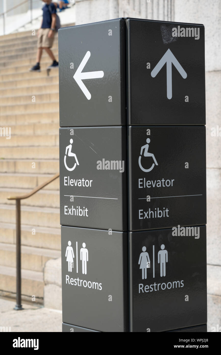 Directional signs show tourists where to access exhibits, restrooms ...